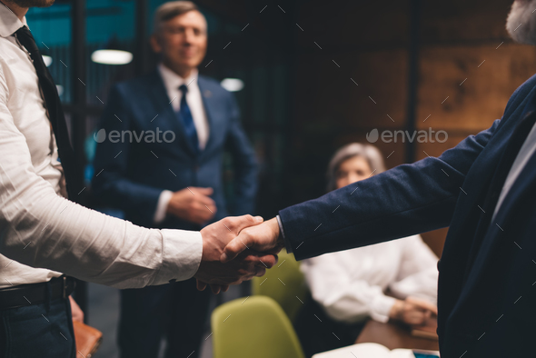 Male employee shaking hands with boss after presentation in workspace ...