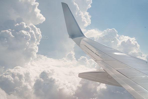 Wing of a white plane aircraft in the sky with white clouds Stock Photo ...