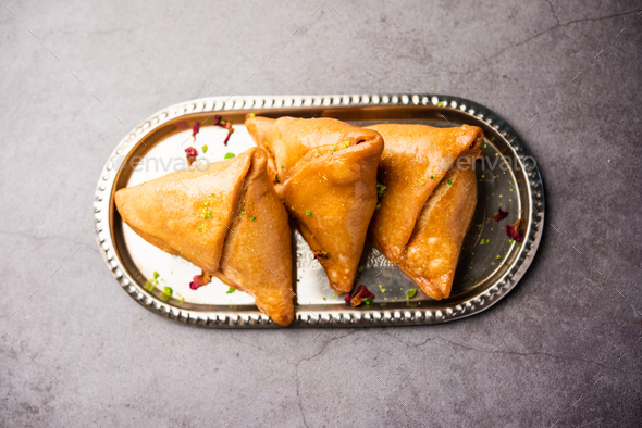 Indian sweet samosa is a Fried pastry soaked in sugar syrup filled with ...