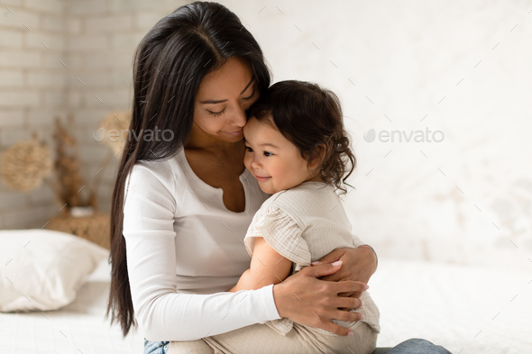 Japanese Mother Hugging Her Little Child Daughter Bonding At Home Stock Photo by Prostock-studio