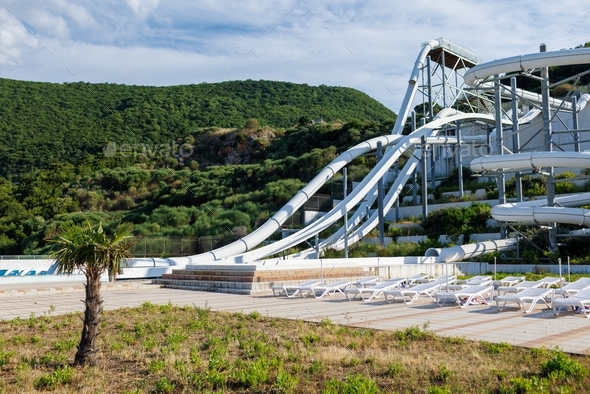Empty water park with high white slides and white sun loungers Stock ...