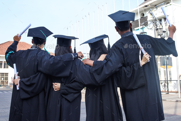 Backside view of group of graduate students hugging each other ...