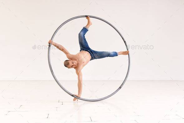 Acrobat performing stunt with cyr wheel Stock Photo by Photology75