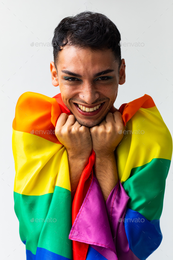 Portrait of happy biracial transgender man holding rainbow flag on ...