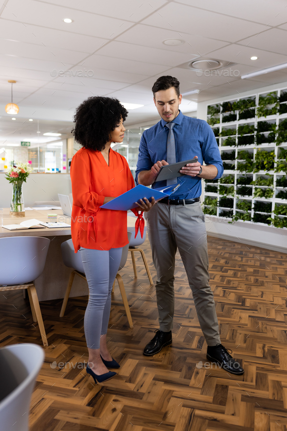 Vertical image of diverse female and male businesspeople working and ...