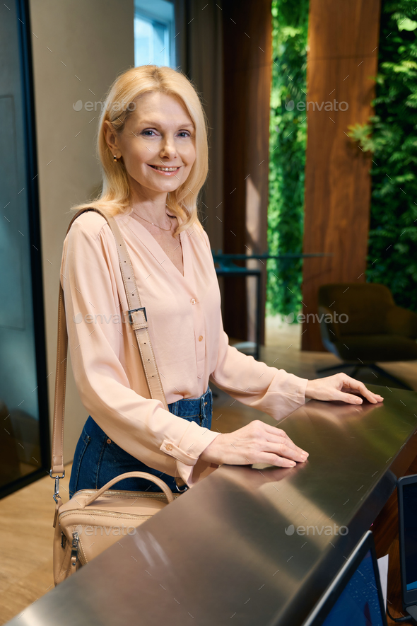 Woman visitor to spa putting her hands on reception desk Stock Photo by ...