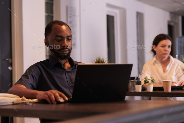 Employee working on laptop in coworking space at workplace Stock Photo ...
