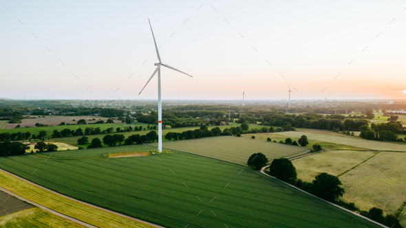 Large wind turbines with blades in field aerial view and sunset blue ...