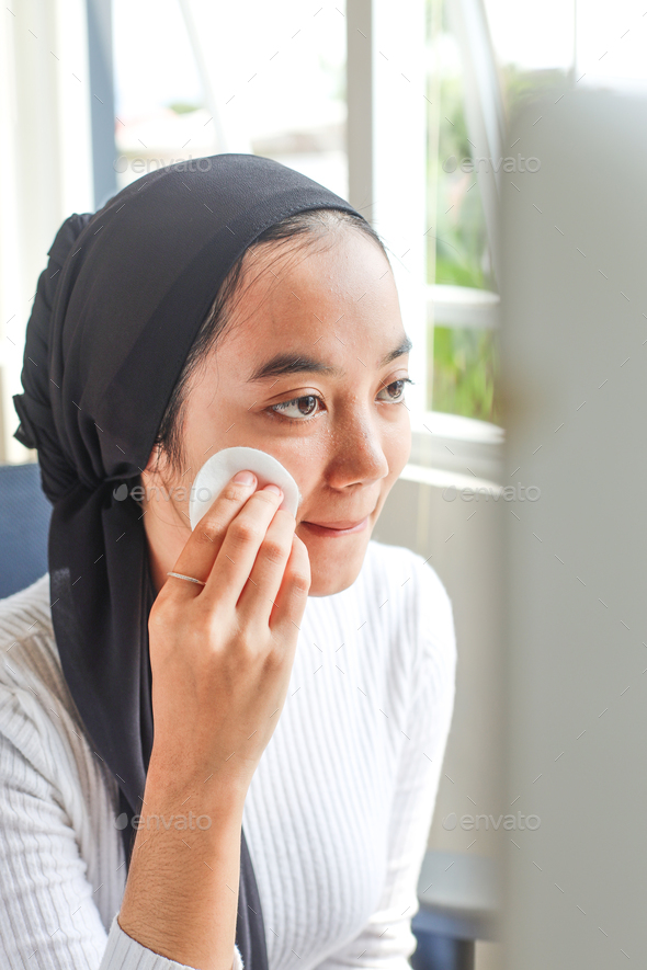 Young beauty Asian Muslim woman cleaning face with cotton clear face ...
