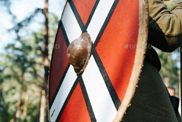 Antique round red shield on the back of a viking outdoors, close-up ...