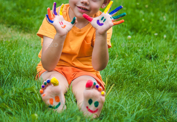 Children's hands in the colors of summer, a smile on the boy's palm ...