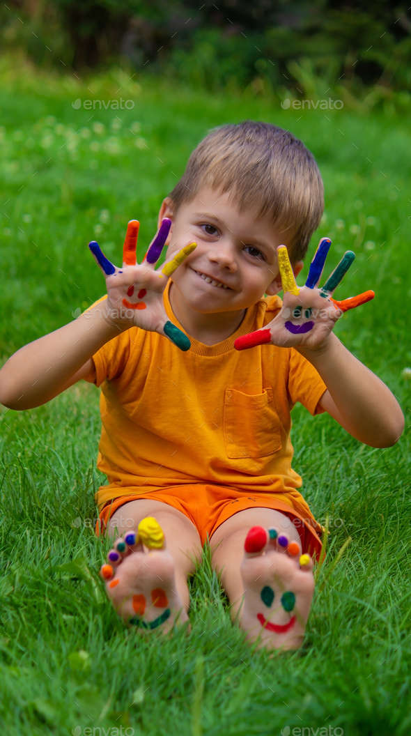 Children's hands in the colors of summer, a smile on the boy's palm ...
