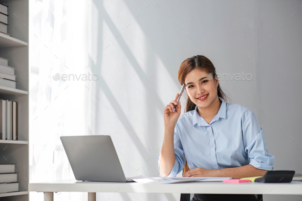 Charming Young asian businesswoman sitting on laptop computer in the ...