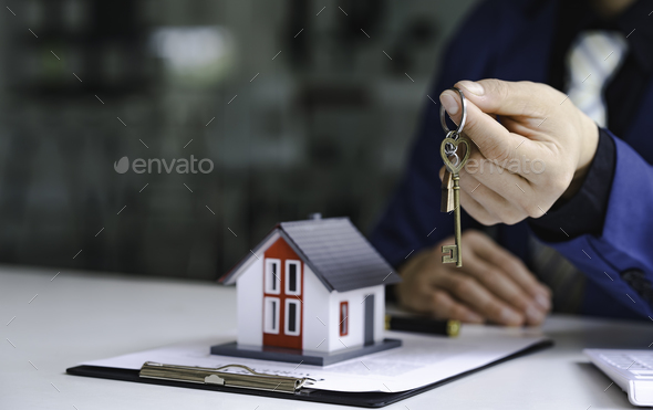 Real estate agent passing house model to his client, Hand of real ...