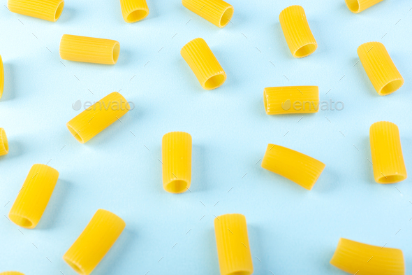 a front view isolated yellow pasta little raw on the blue background ...