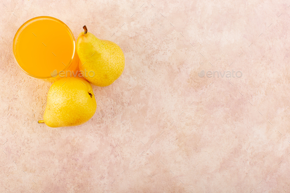 a top view orange juice inside little glass along with pears on the ...