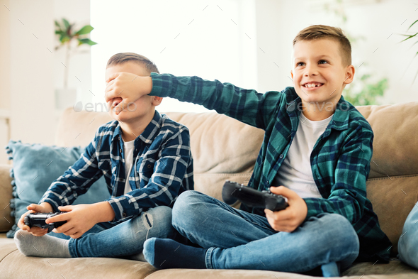 child brother friend having fun playing console laughing happy kid ...