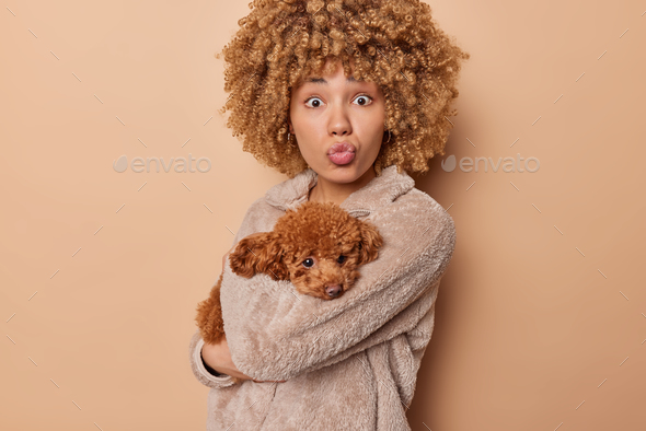 Pure companionship. Lovely surprised curly woman carries her loyal ...