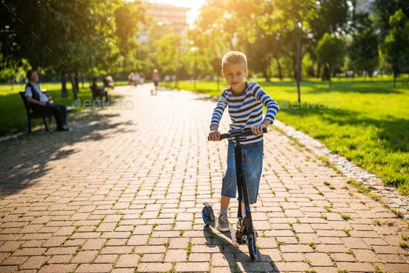 Boy riding scooter Stock Photo by djoronimo | PhotoDune