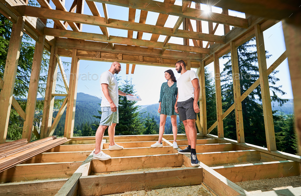 Man designer with plan showing the process of constructing wooden ...