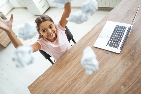 The happy girl throwing a piece of paper at the desk Stock Photo by artemp3