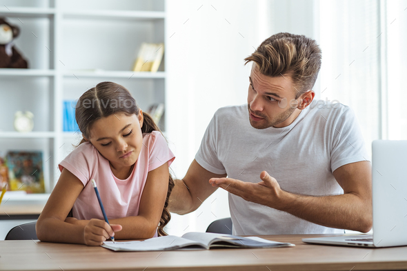 The angry father and a daughter doing homework at the desk Stock Photo ...