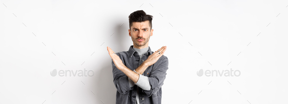 Angry man show cross gesture to stop or say no, frowning and looking ...