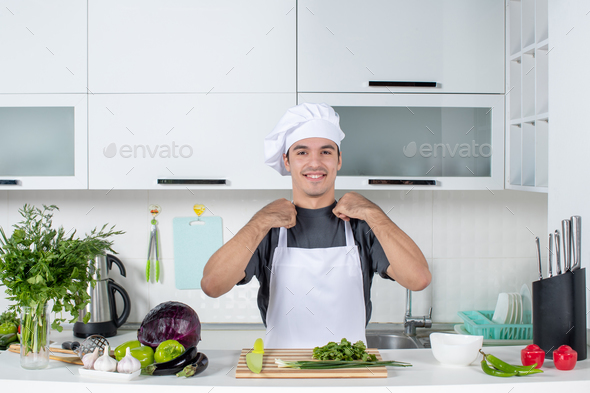front view young cook in uniform standing behind table Stock Photo by ...