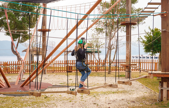 Teenage teen girl in climbing harness equipment, green sports safety ...