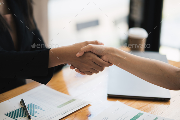 Recruiter shaking hands with a young female candidate after a job ...