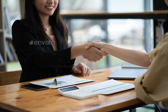 Recruiter shaking hands with a young female candidate after a job ...