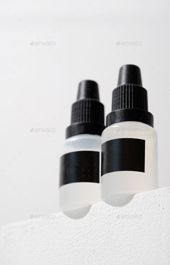 Set of plastic dropper bottles with liquid with black blank stickers ...