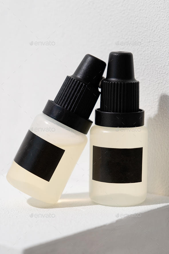 Set of plastic dropper bottles with liquid with black blank stickers ...
