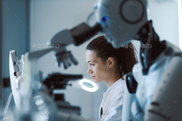 AI robot examining samples under a microscope Stock Photo by stockasso