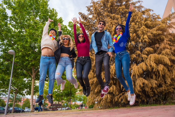 Diverse young people jumping for joy in a summer party portrait - Happy hour, lunch break and ...