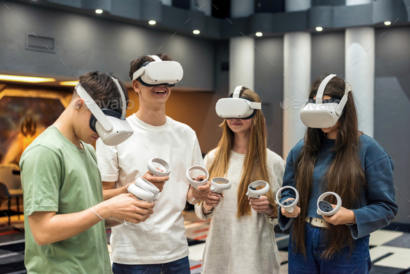 A group of four young friends talking and playing games using VR ...
