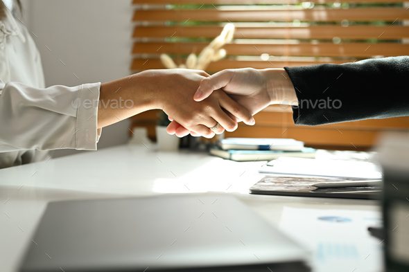 Cropped image advisor shaking hands with client after meeting in office ...