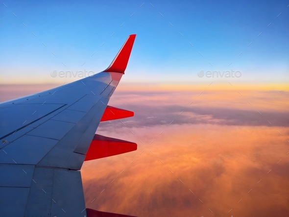 Airplane wing over the sunset sky with beautiful golden clouds Stock ...
