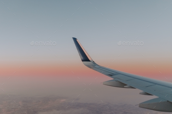 Horizontal shot of airliner wing with the background of colorful sky ...
