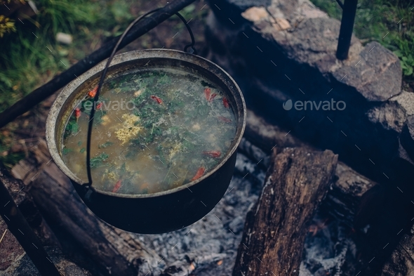 High angle closeup shot of soup in an iron bowl hanged above the ...
