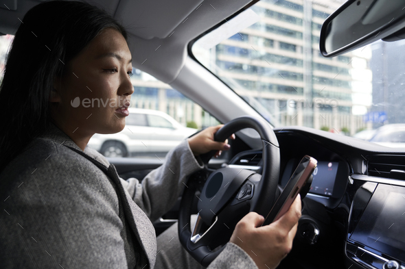 Chinese woman using mobile phone while driving a car Stock Photo by ...