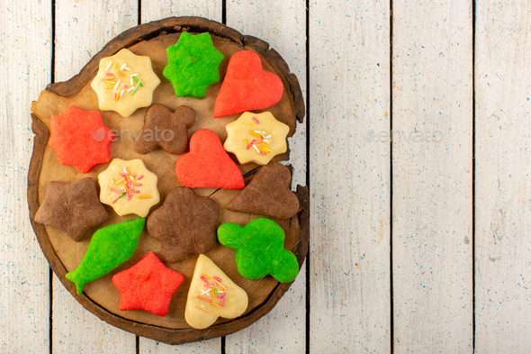 a top view colorful delicious cookies different formed on the brown ...
