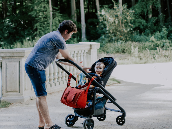 Caucasian young and handsome dad stretches his hands to his little ...