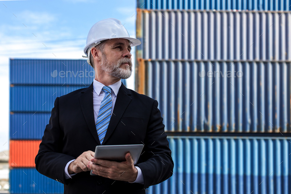 Business man holding a tablet and checking the list of export and ...
