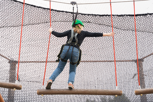 Teenage teen girl in climbing harness equipment, green sports safety ...