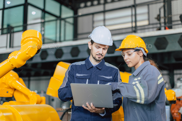 engineer team working together inspection quality robot arm in robot assembly industry plant ...