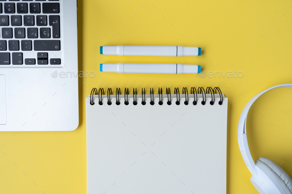 Top view of a student's desk with a laptop, a notepad, and other ...