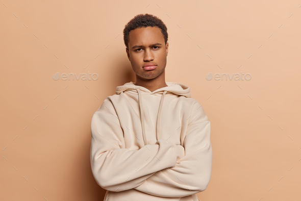 Displeased dark skinned man has stern expression brows furrowed and ...