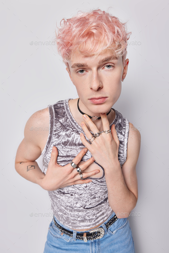 Serious self confident transgender guy with pink hair dressed in ...