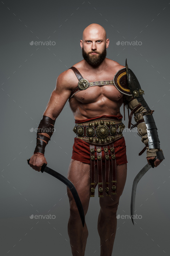Bald and bearded gladiator poses standing tall with two swords Stock ...